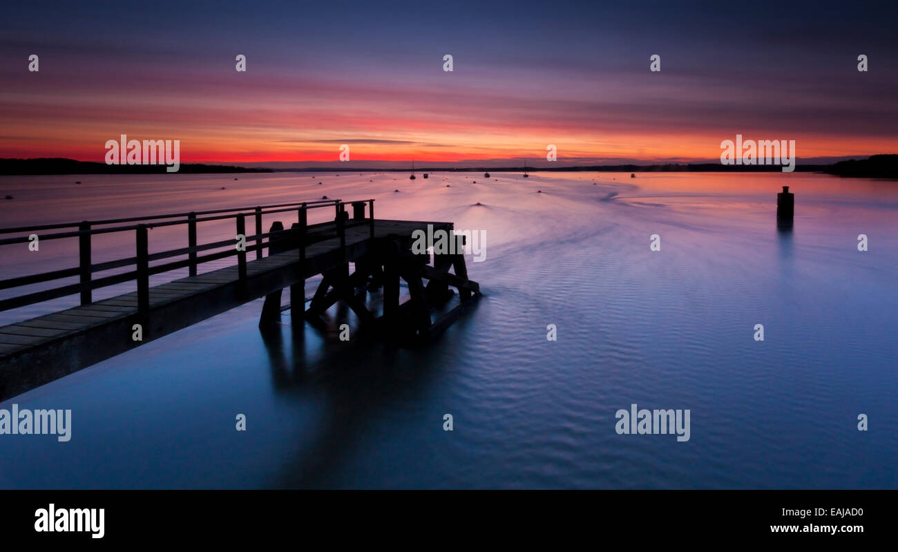 The Sun sets over Poole Harbour in Dorset. Hamworthy pier jetty Stock ...