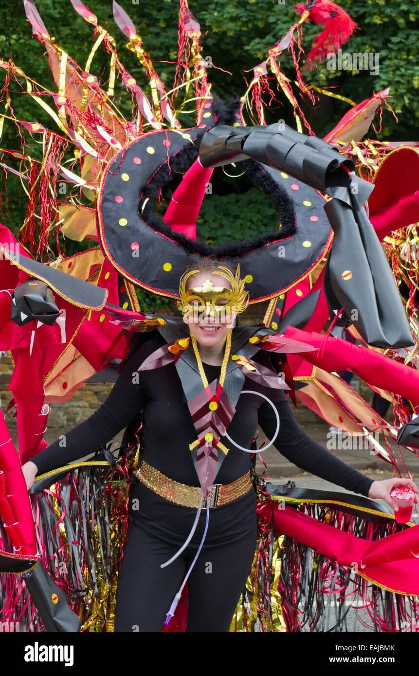 Female dancer in a red and black costume entertains at a street ...