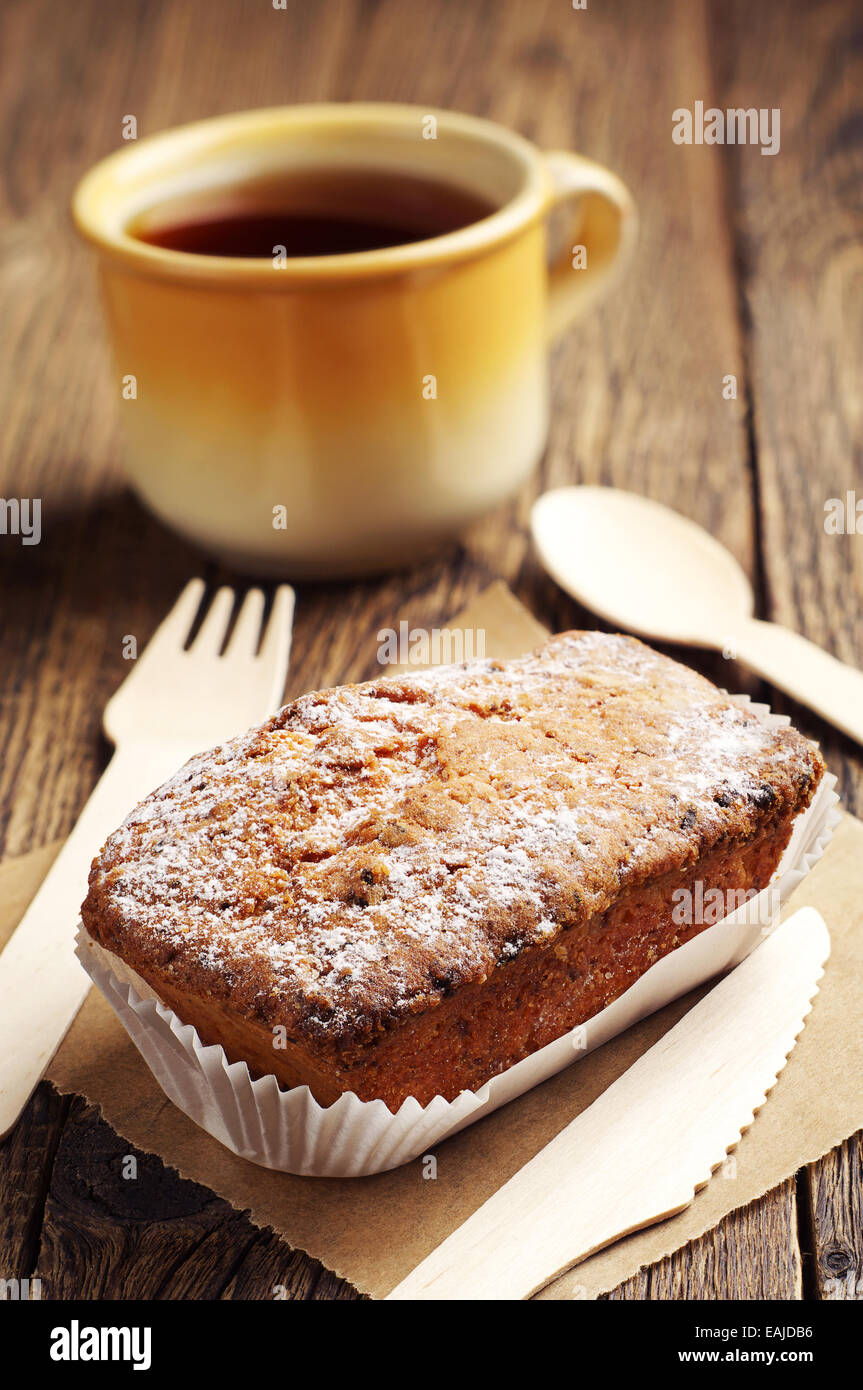 Tasty cupcake, cup of tea and wooden cutlery on table Stock Photo - Alamy