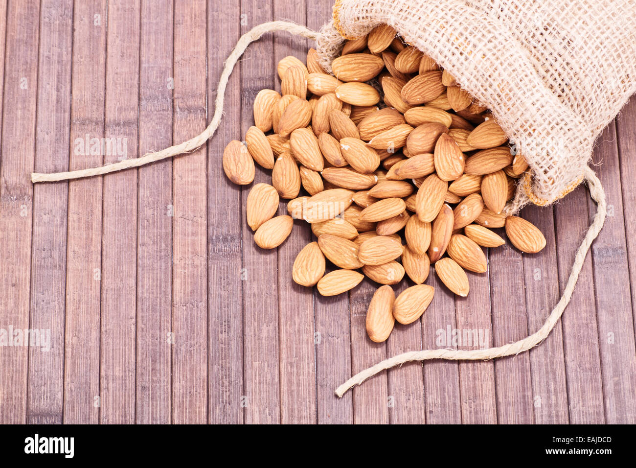 Close up shot of spilled almonds spilled from a burlap sack, on a ...