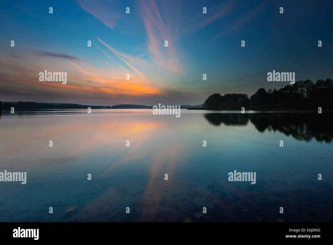 Tranquil sunset over blue lake Stock Photo - Alamy