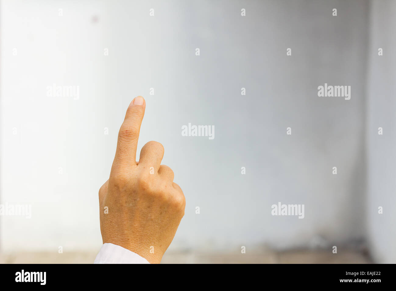Hand simulating pressing a button on blank white wall Stock Photo - Alamy