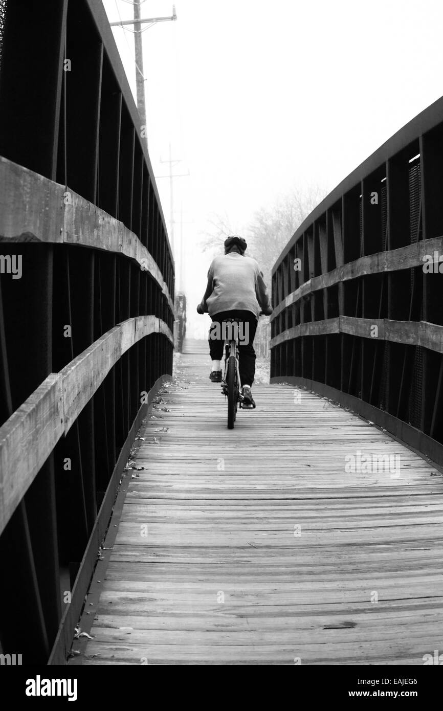 Biker riding a bike across the bridge Stock Photo - Alamy