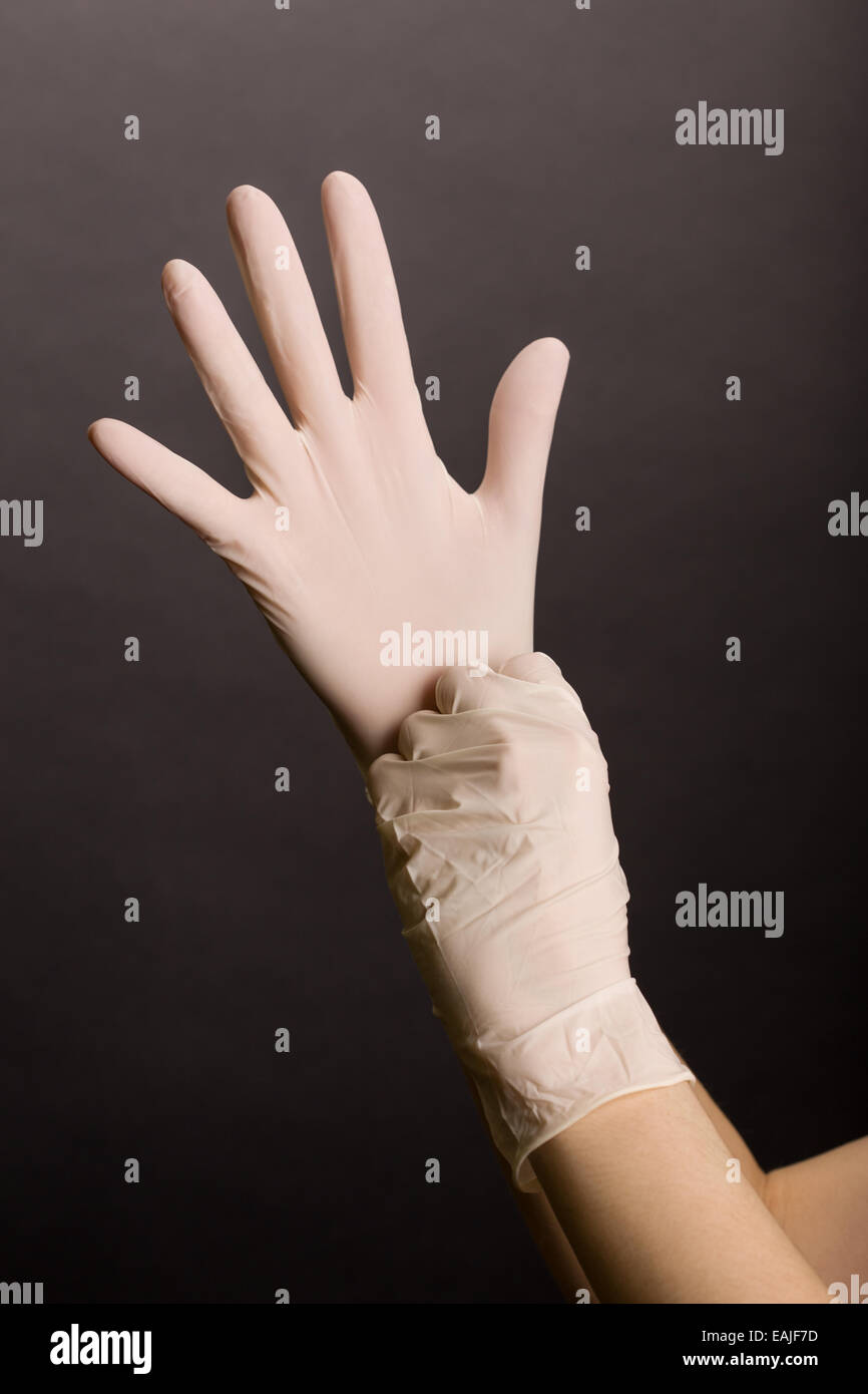 Putting on latex gloves Stock Photo - Alamy