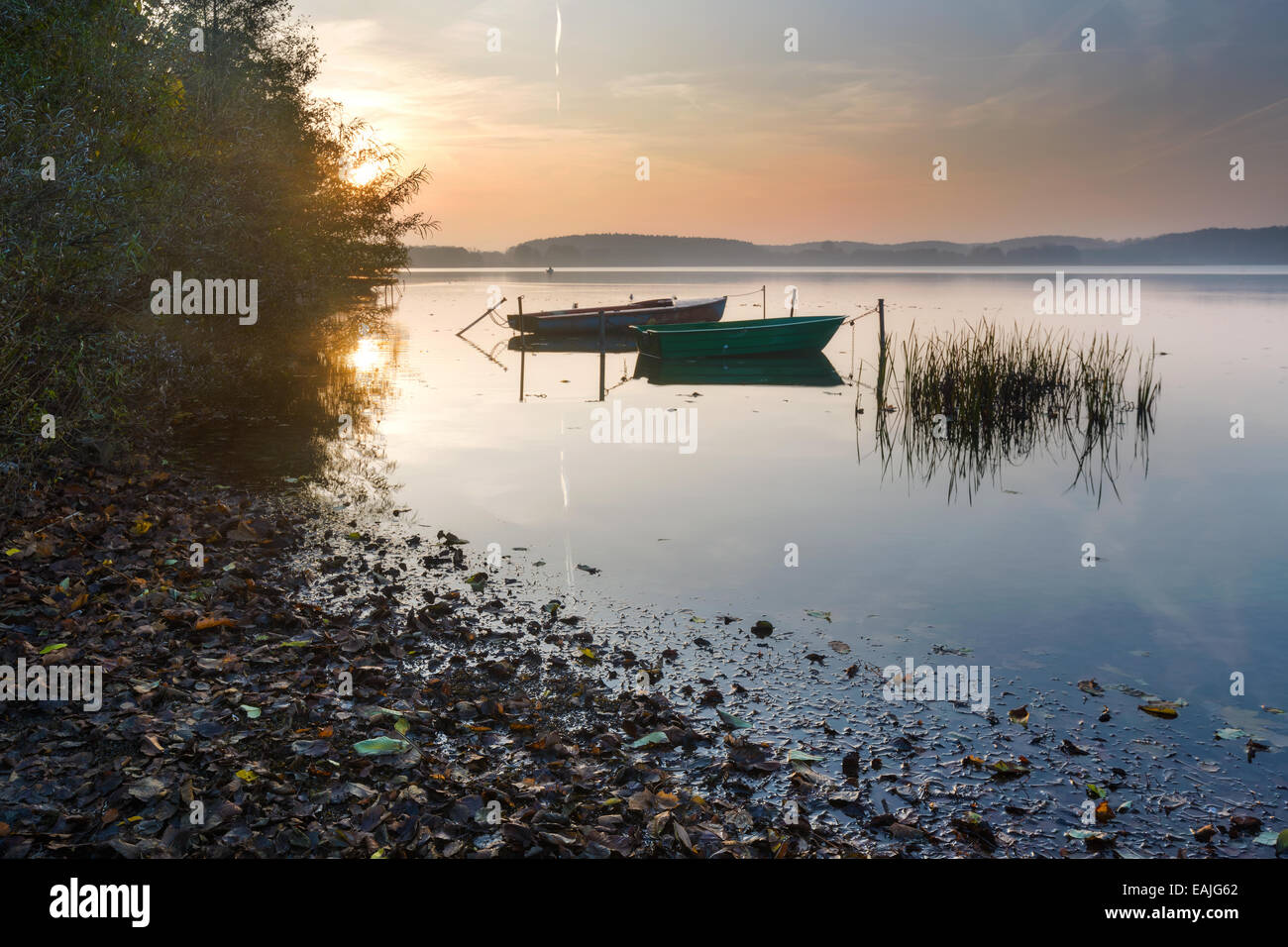 Boat on calm lake at sunset Stock Photo - Alamy