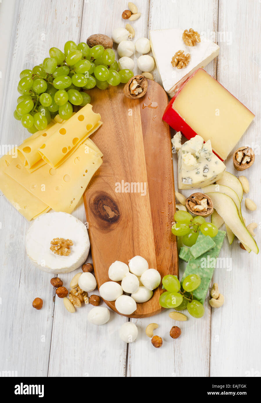 various types of cheese with fruits and nuts on a wooden table Stock ...