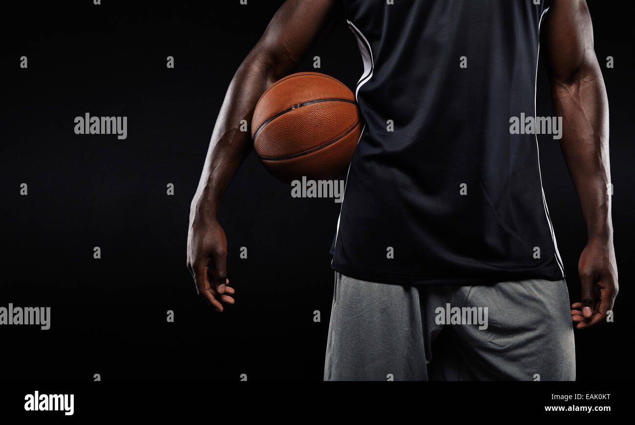 Cropped image of Afro-American basketball player holding a ball against ...