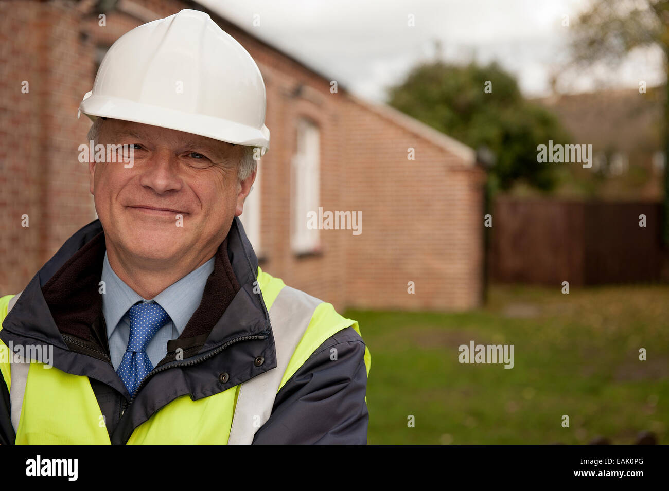 Outdoors portrait of a civil engineer wearing a white safety helmet ...