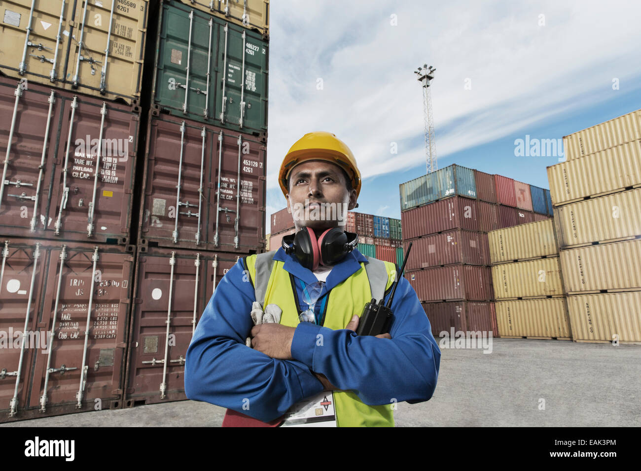 Worker standing near cargo containers Stock Photo - Alamy