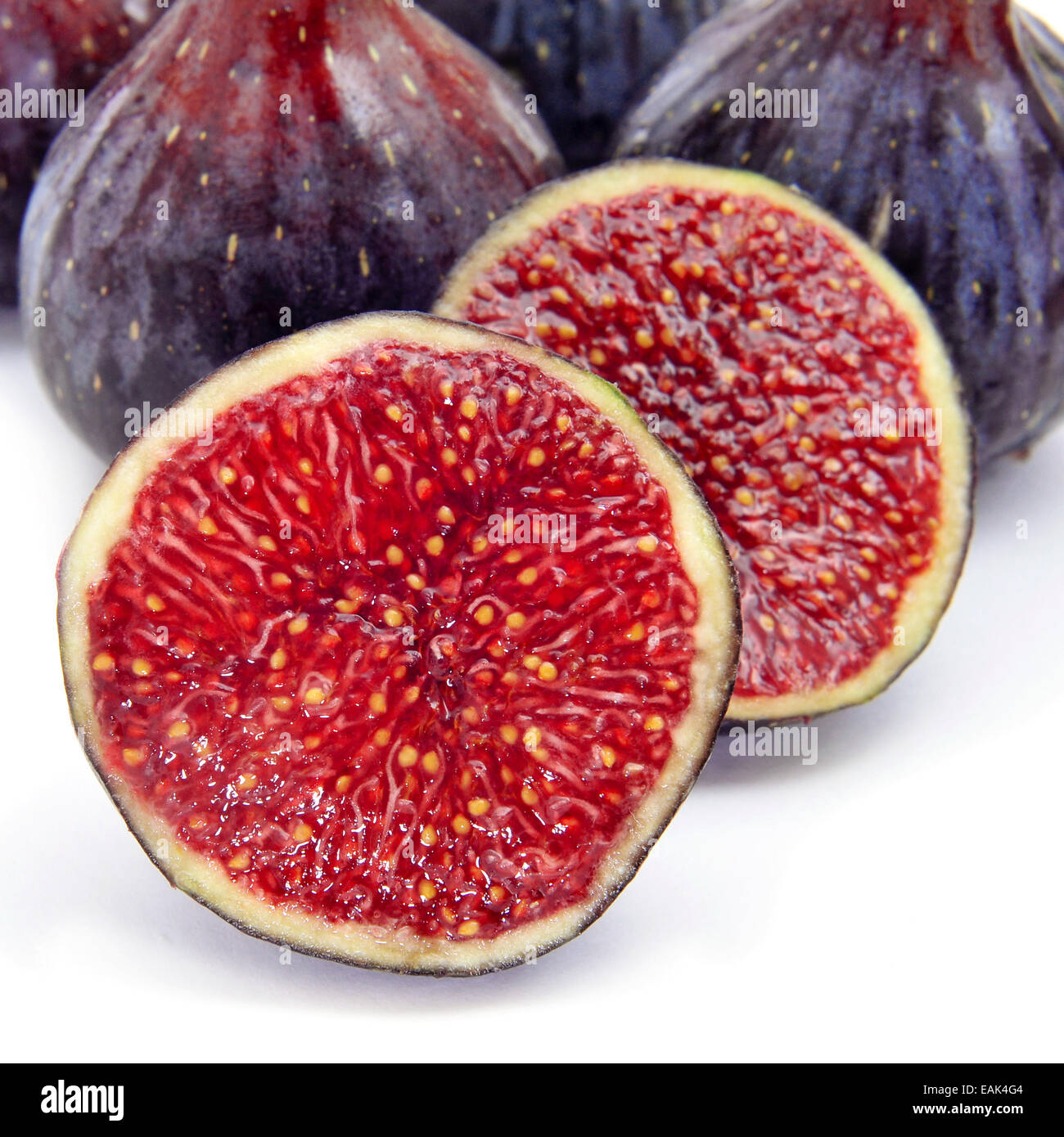 some figs, one of them cut in half, on a white background Stock Photo ...