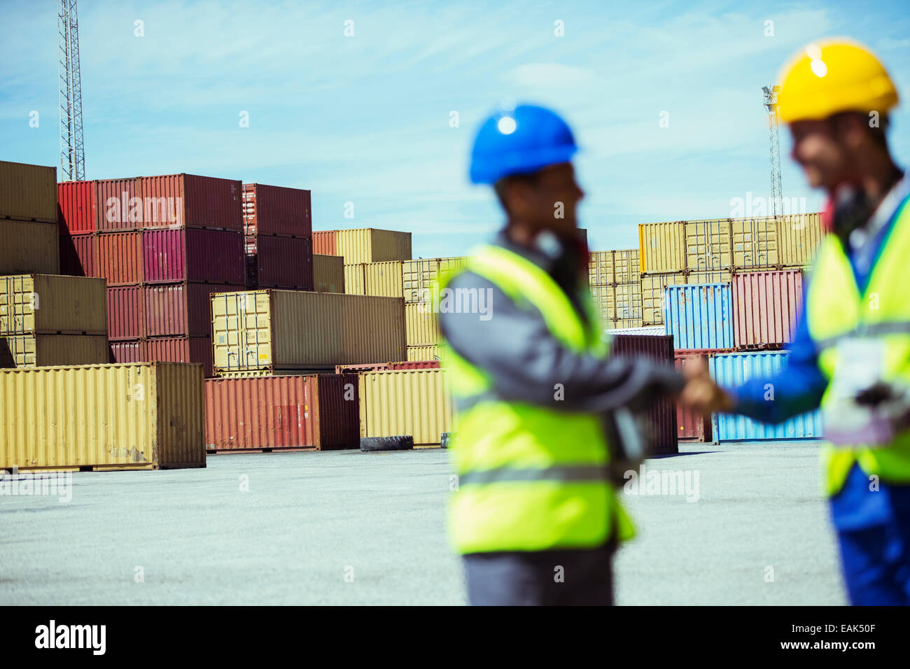 Worker and businessman shaking hands near cargo containers Stock Photo ...