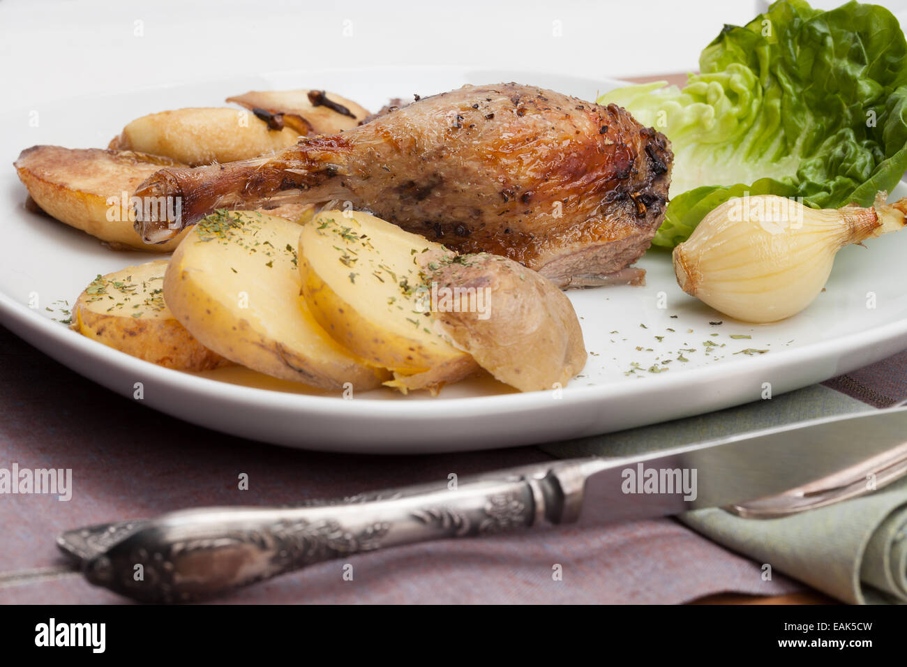 Roast leg of duck with potatoes and fried apples Stock Photo - Alamy
