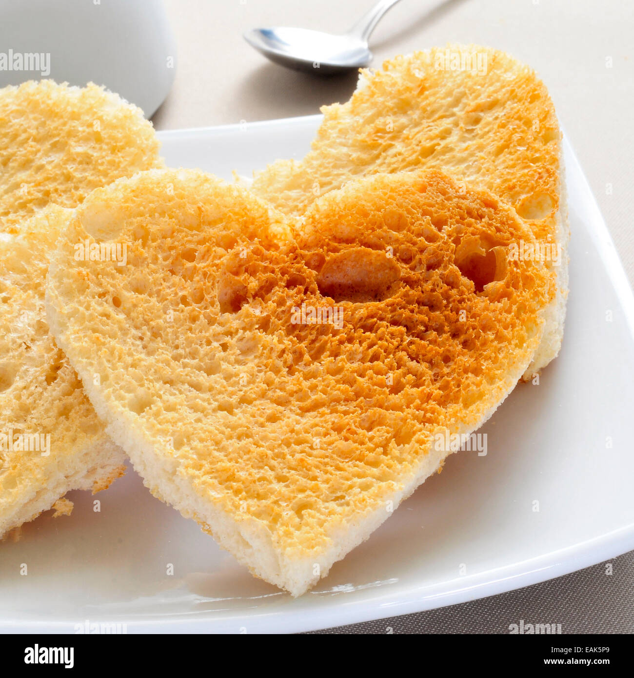 a plate with some heart-shaped toasts served on a set table Stock Photo ...