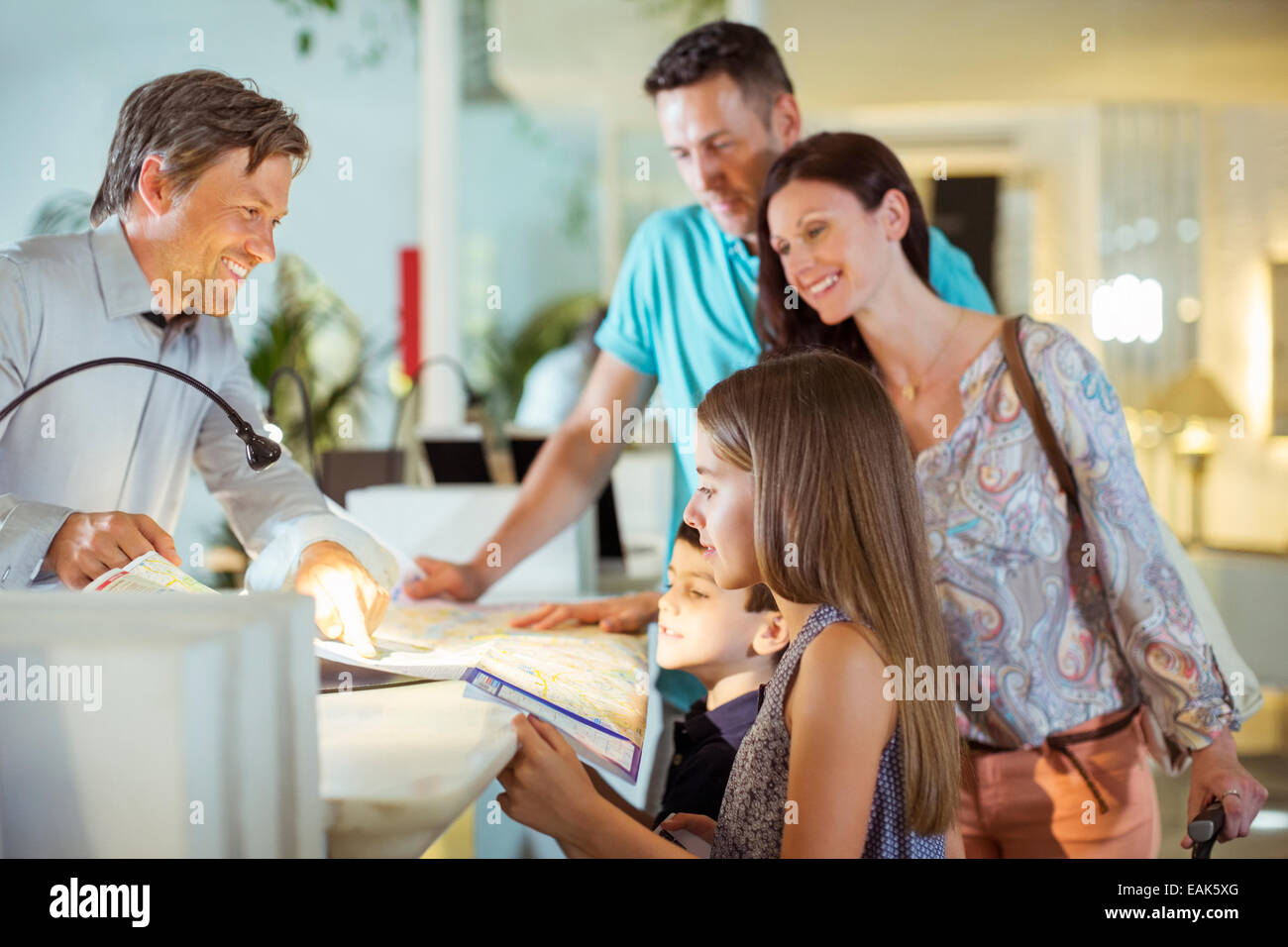 Family with two children at reception desk in hotel lobby Stock Photo ...