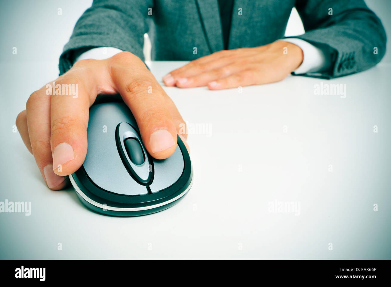 a businessman sitting in a desk using a computer mouse Stock Photo - Alamy