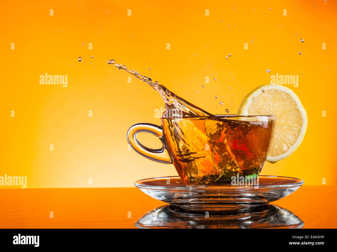 Cup of tea on glass with orange background Stock Photo - Alamy