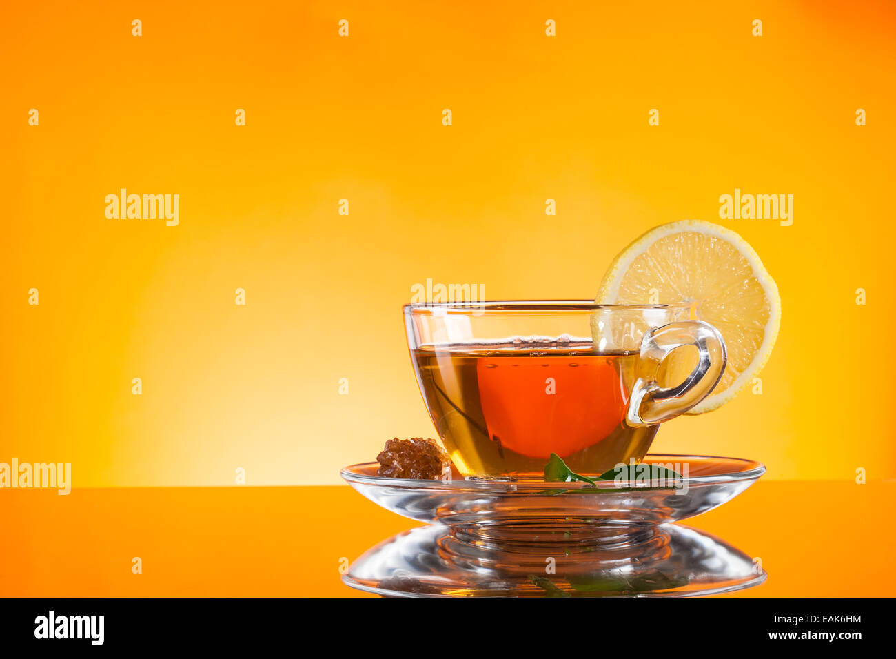 Cup of tea on glass with orange background Stock Photo - Alamy