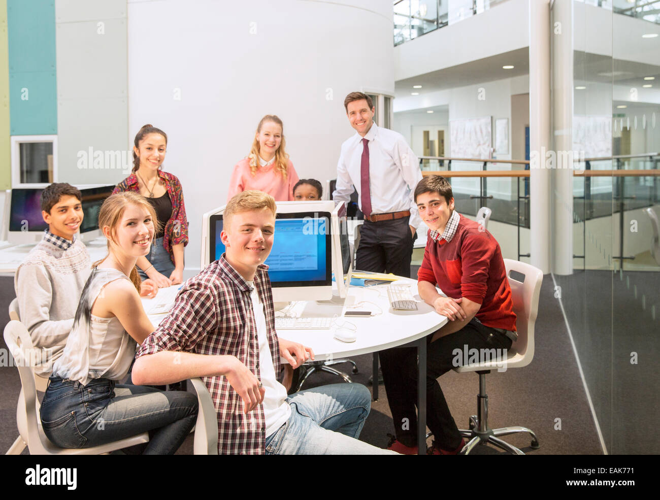 Group portrait of teenage students with their teacher at table Stock ...