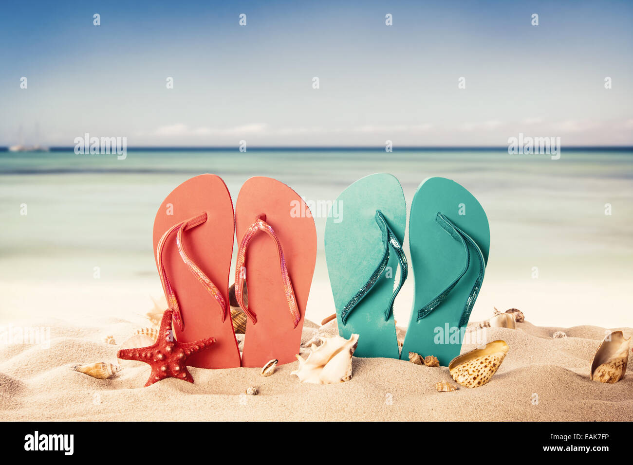 Summer concept with sandy beach, shells and colored sandals Stock Photo ...