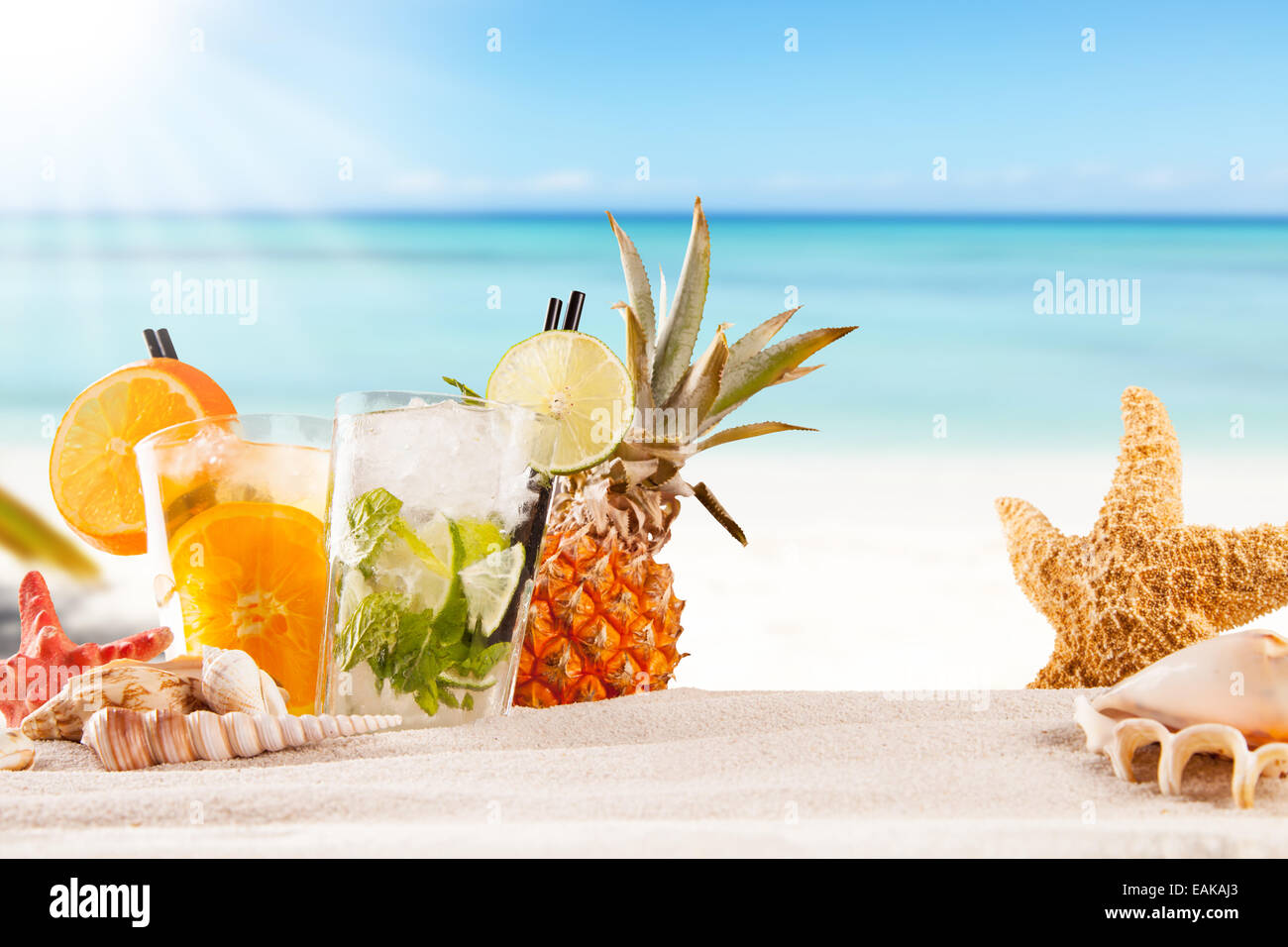 Exotic summer drinks with sea shells and stars, blur sandy beach on ...
