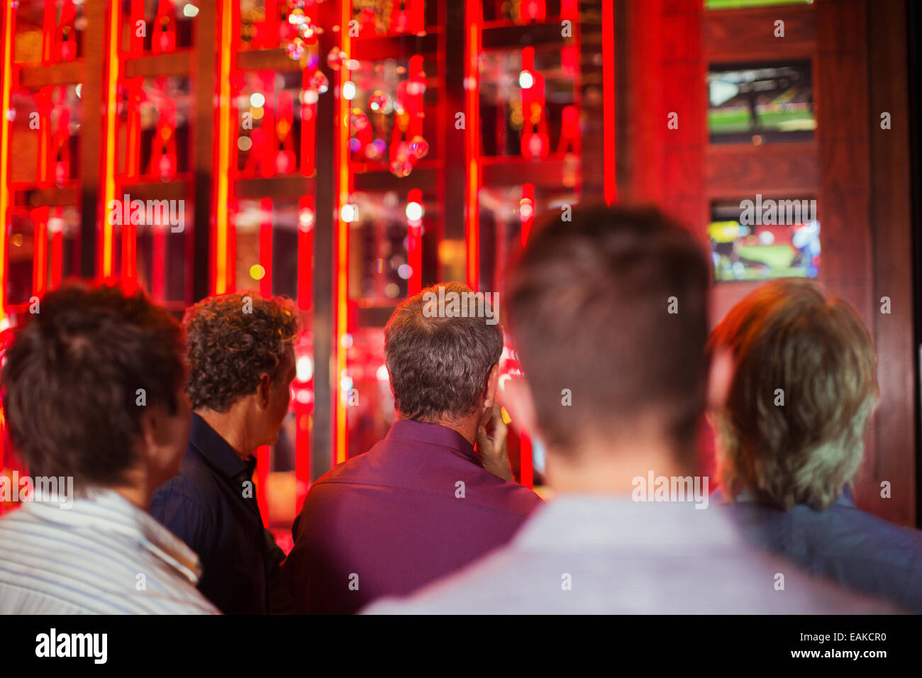 Rear view of group of men watching TV in bar Stock Photo - Alamy