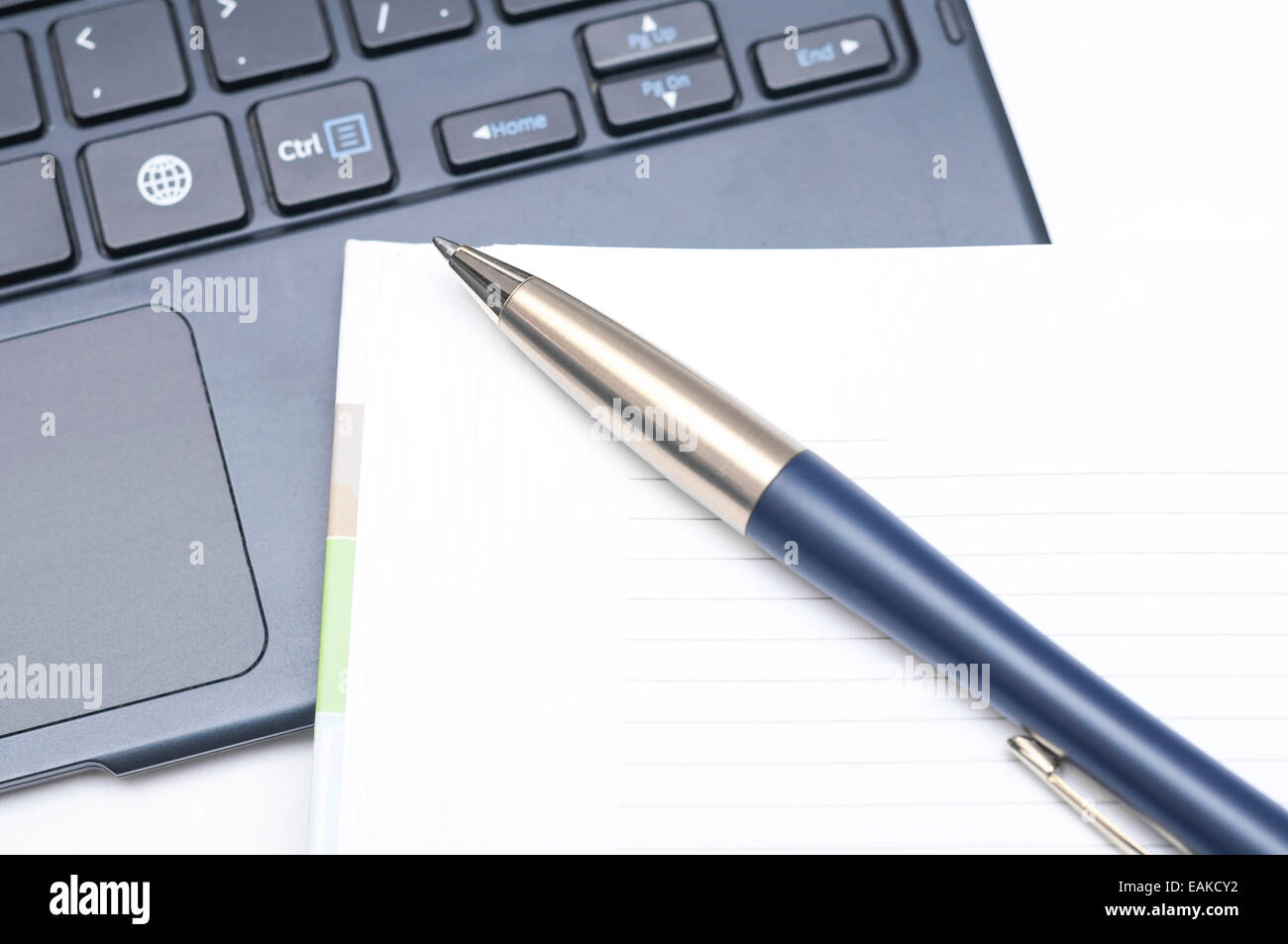 Notepad and pen on keyboard on white background Stock Photo - Alamy
