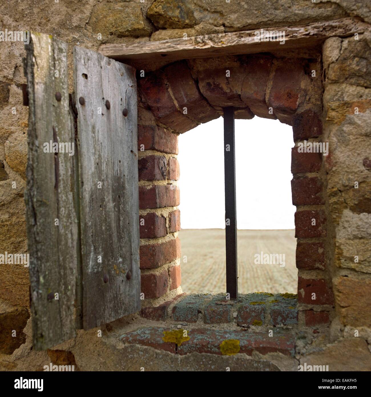 Window in a derelict house reveals a wide field in rural France ...