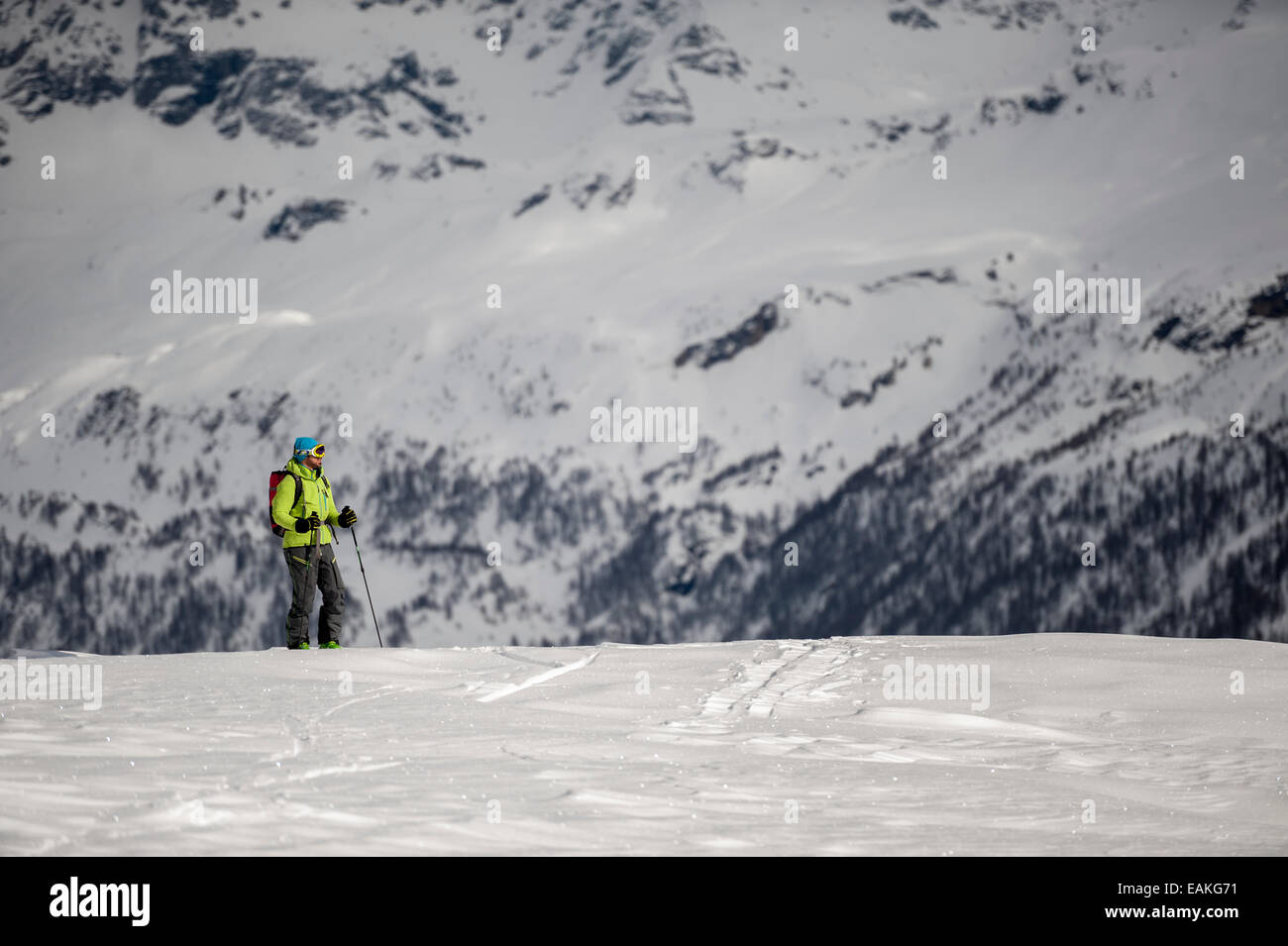 Skier stands on the edge of steep slope in Devero Valley with snowy ...