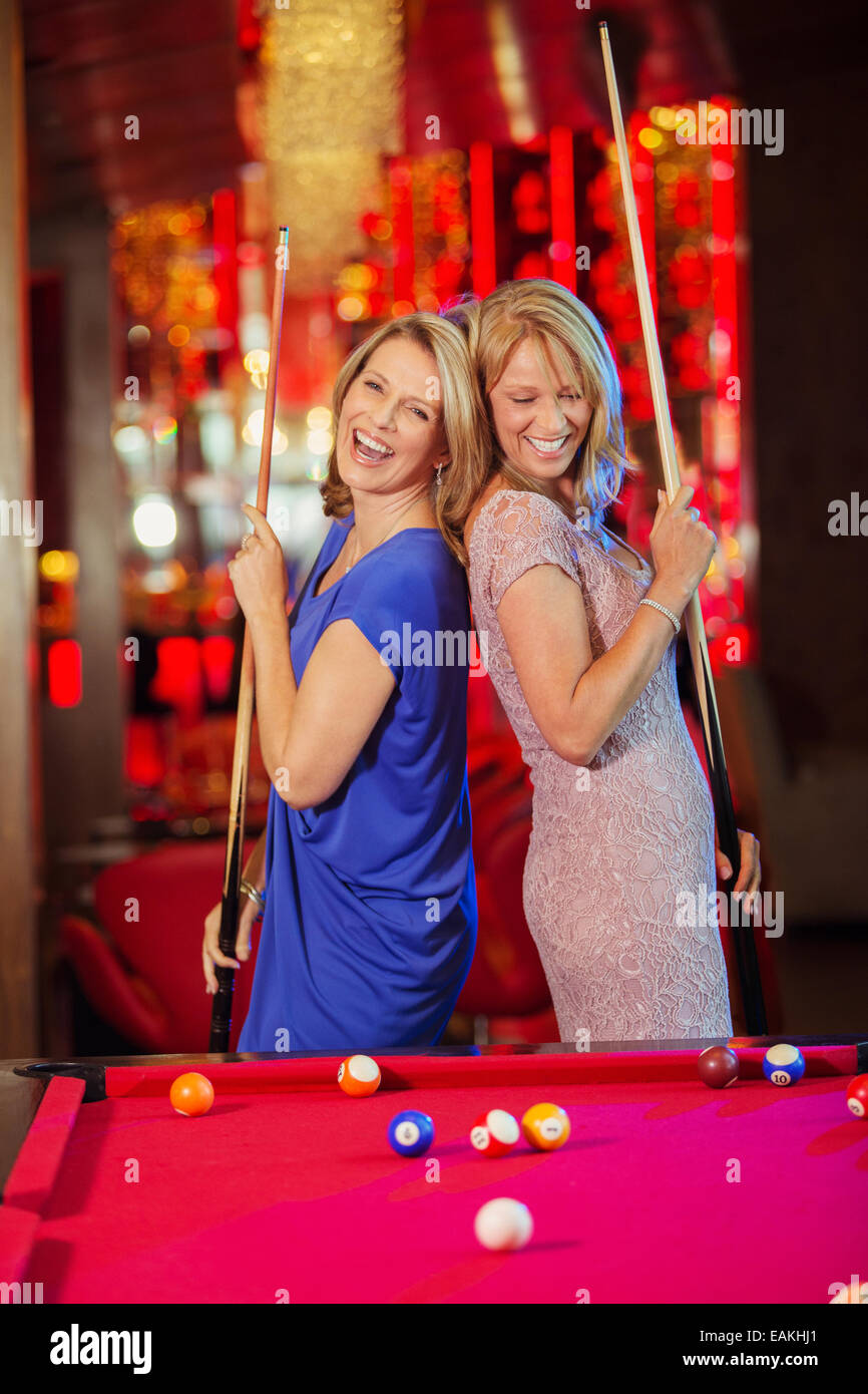 Two mature women laughing and playing pool in nightclub Stock Photo - Alamy