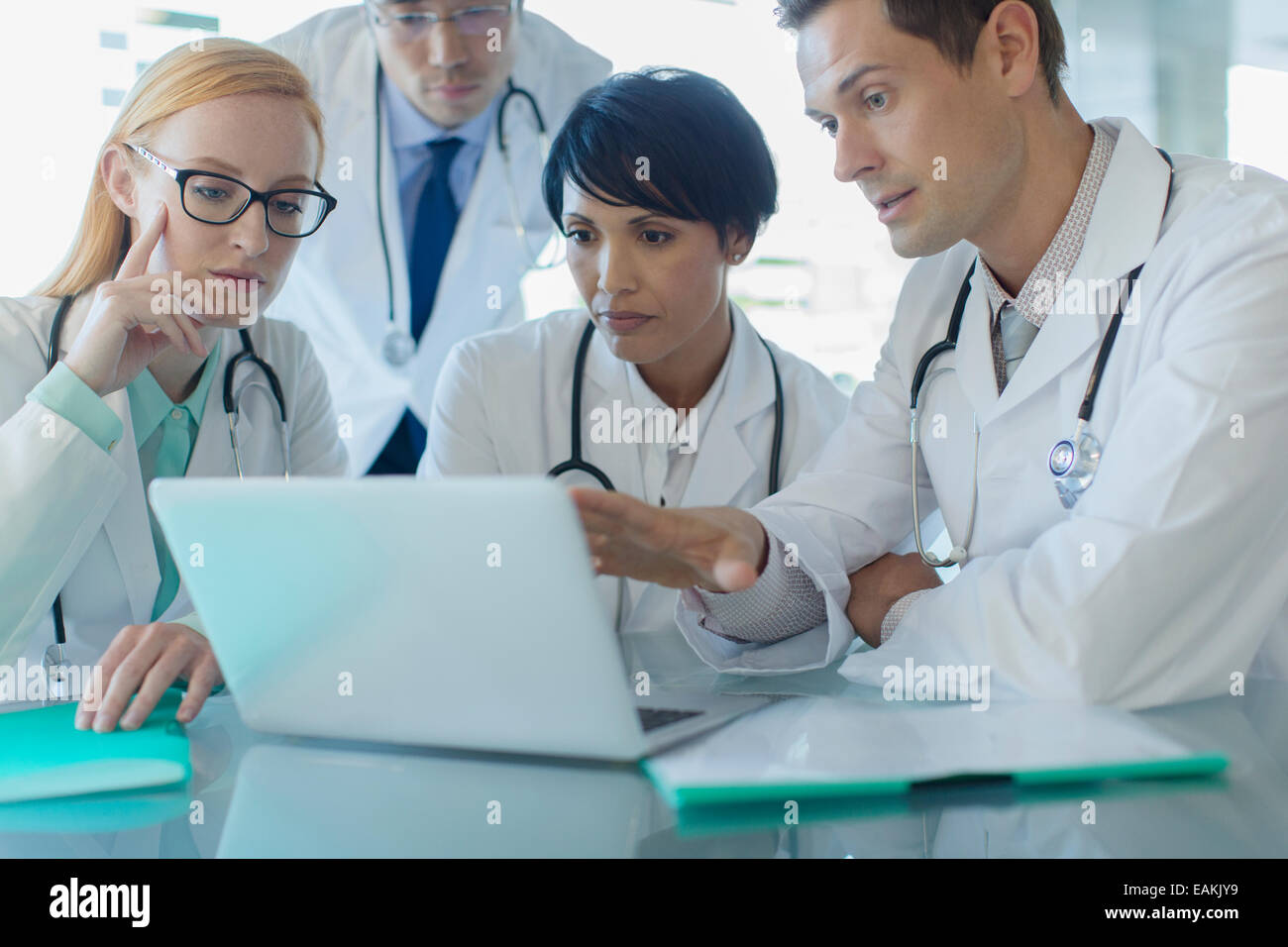 Doctors using laptop and discussing patient's treatment Stock Photo - Alamy