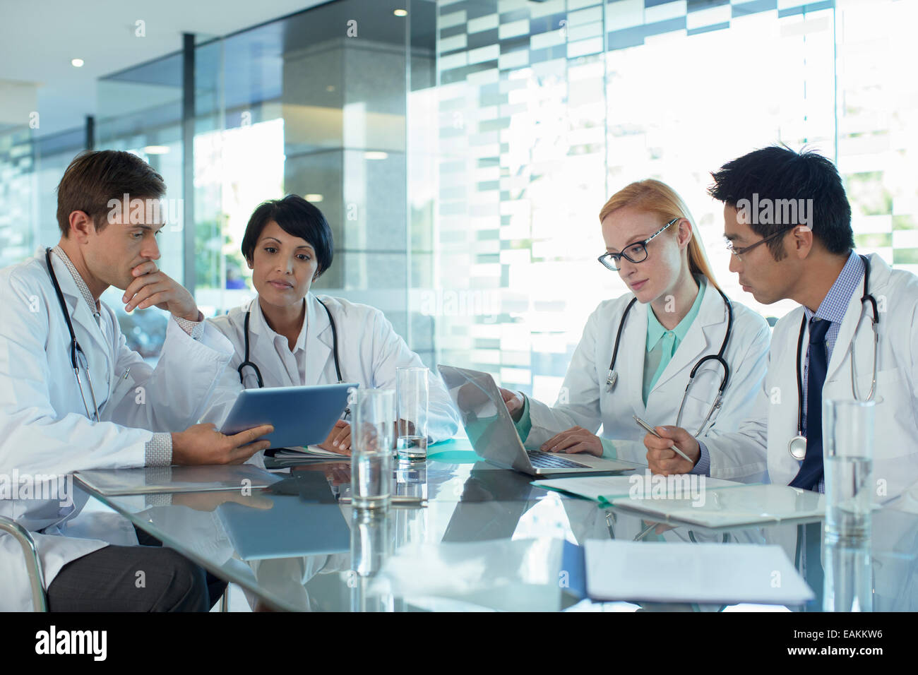 Doctors using laptop and discussing patient's treatment Stock Photo - Alamy