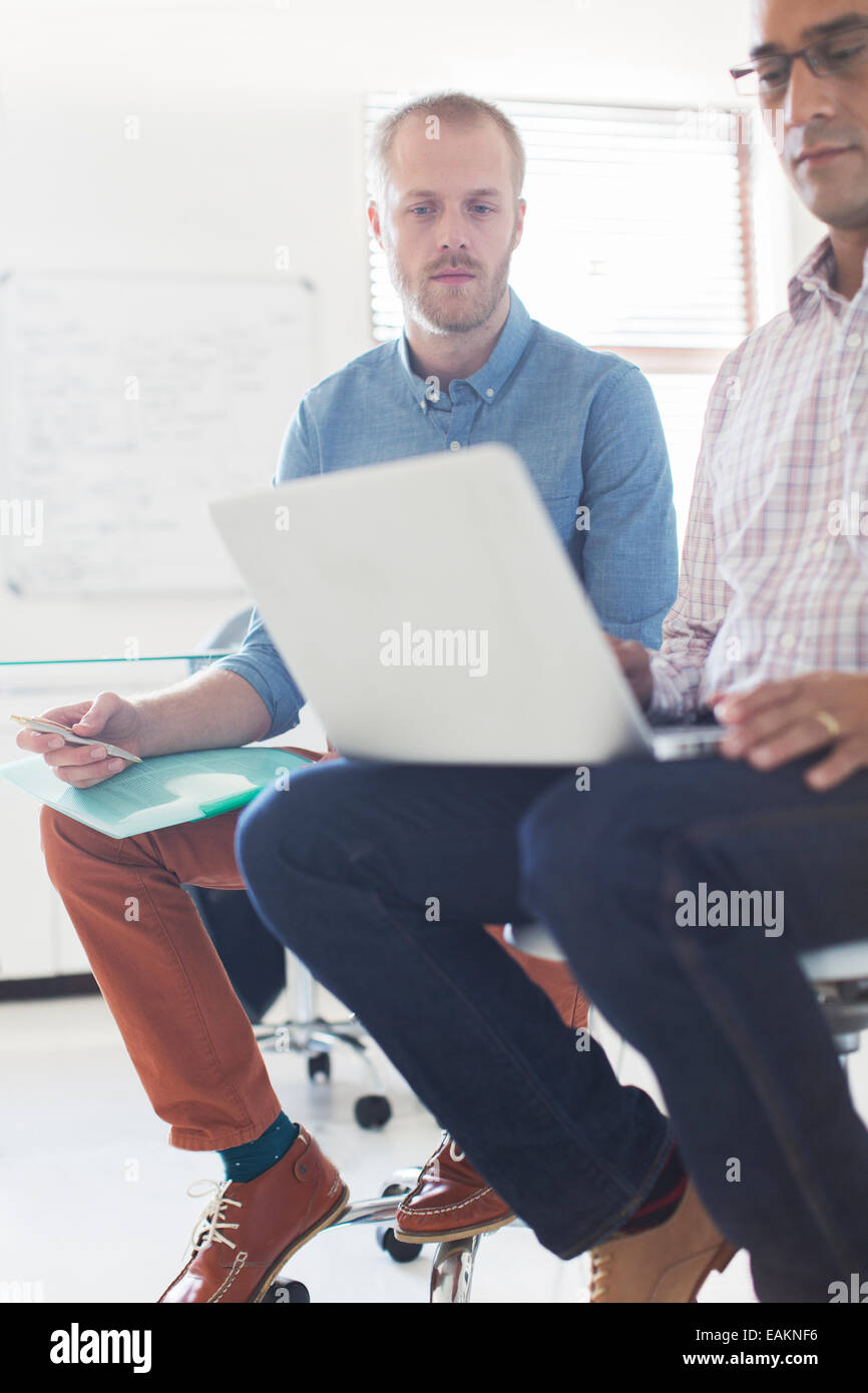 Two businessmen using laptop in office Stock Photo - Alamy