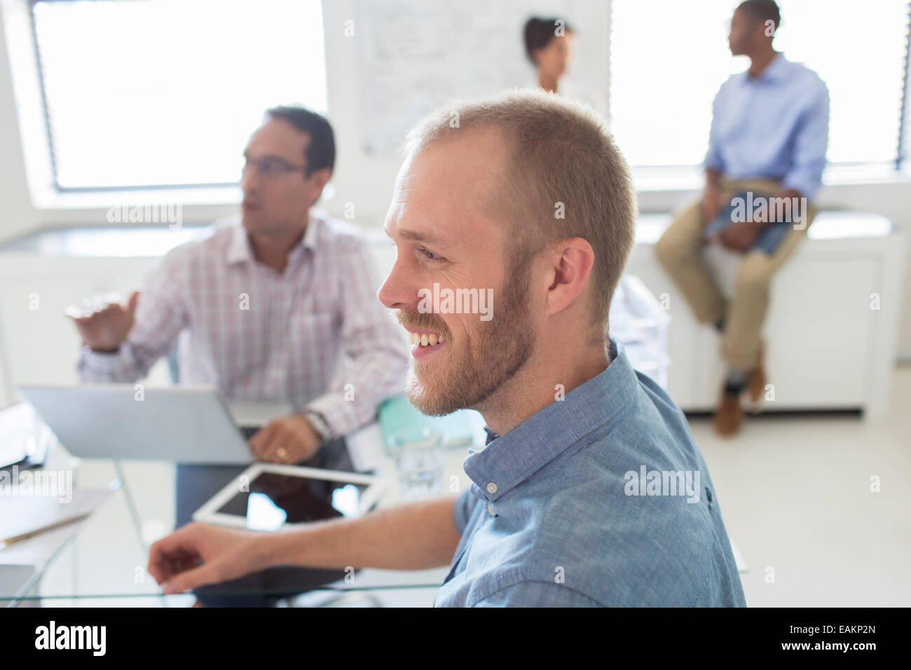 Smiling people during meeting in office Stock Photo - Alamy