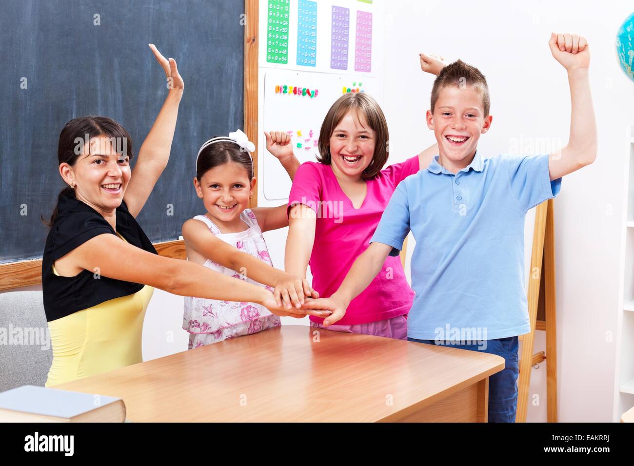 Happy winner group of united students and teacher in school, raising ...