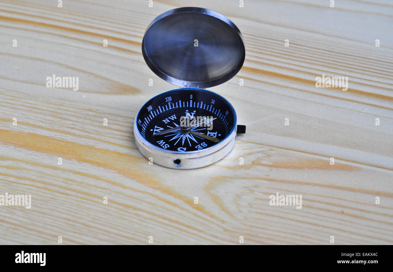 The compass on the Board. The magnetic compass lies on textured wood ...