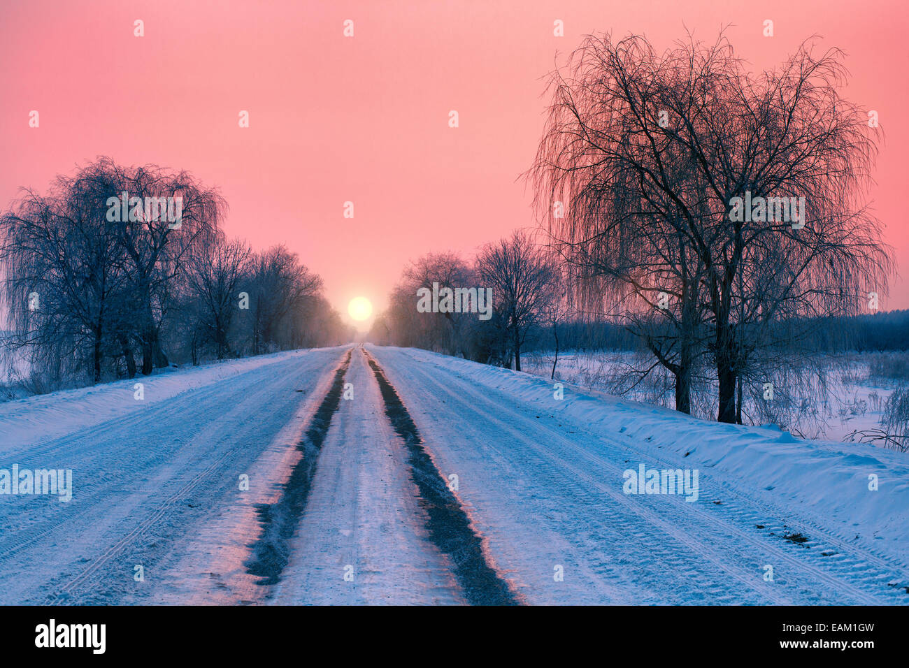 Beautiful pink sunrise over snowy road Stock Photo - Alamy