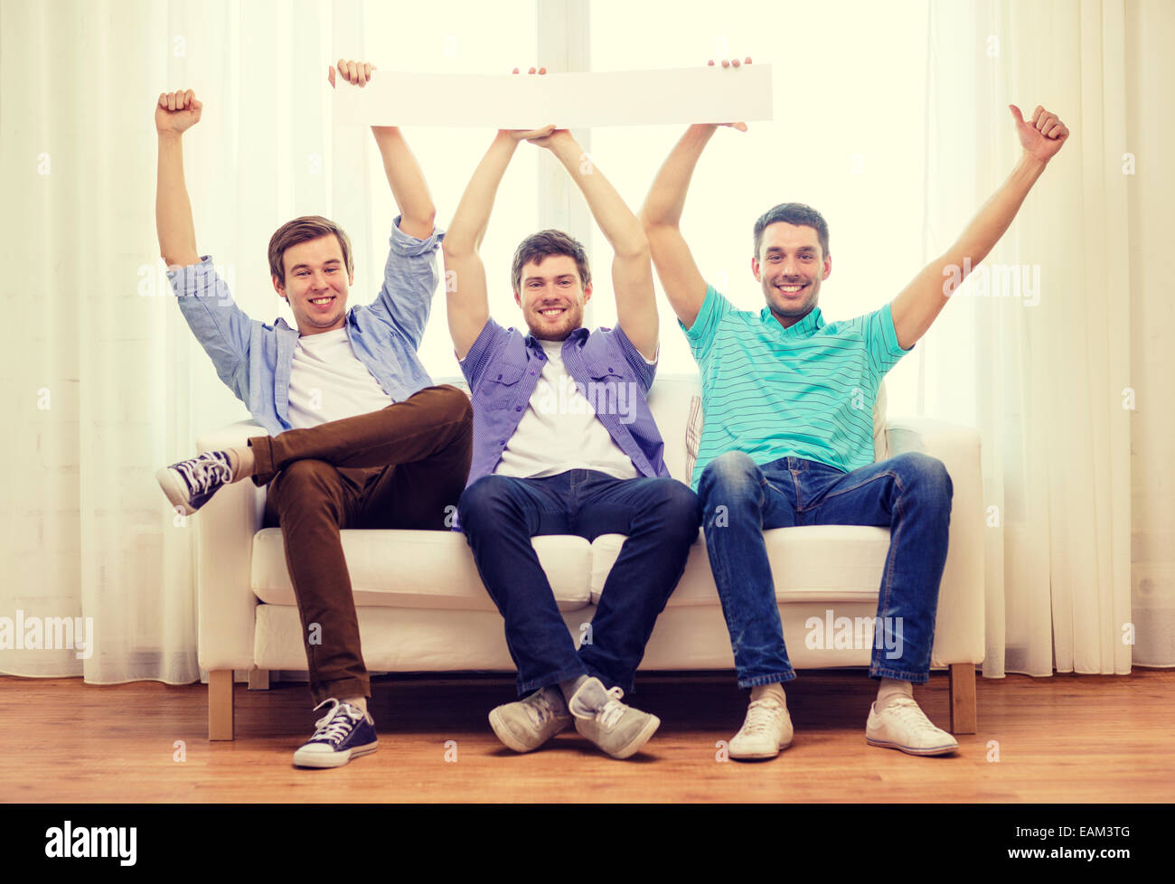 smiling male friends holding white blank banner Stock Photo - Alamy
