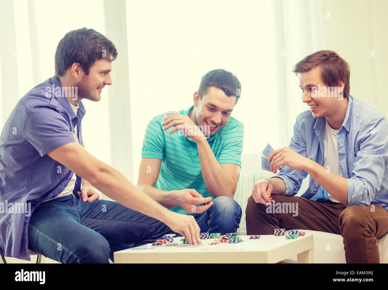 happy three male friends playing poker at home Stock Photo - Alamy