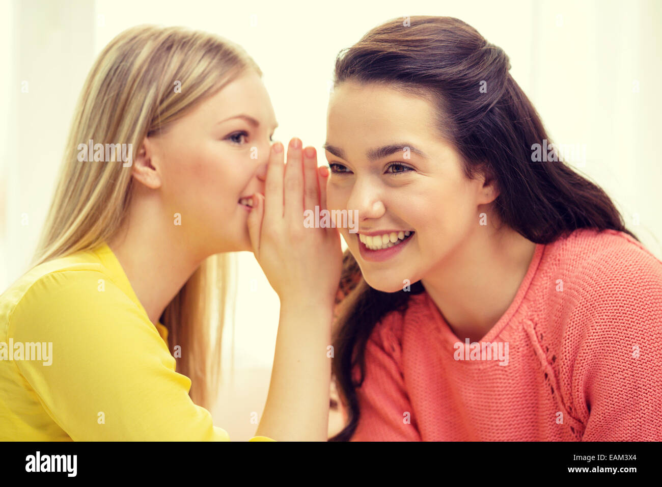 one girl telling another secret Stock Photo - Alamy