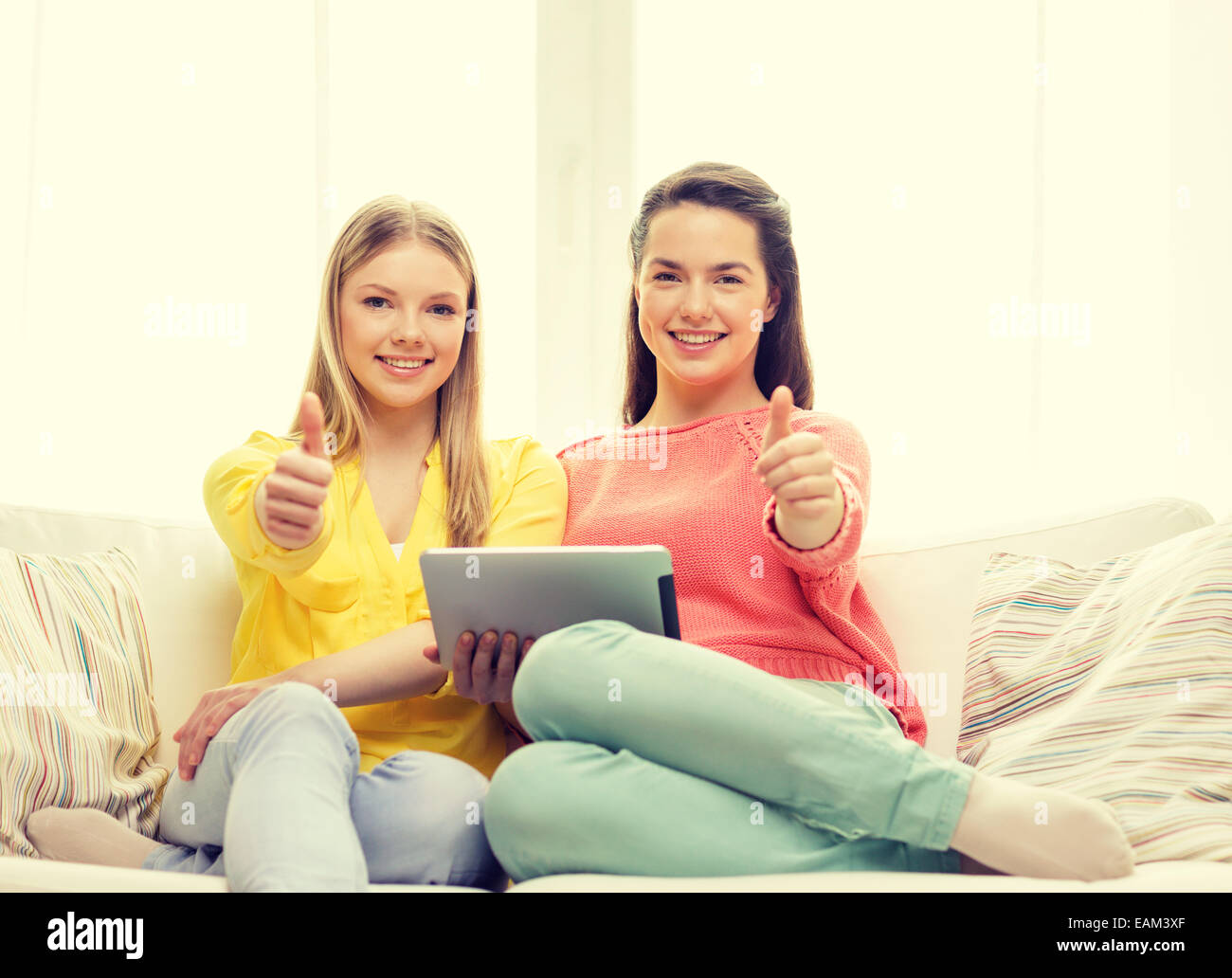 two smiling teenage girls with tablet pc at home Stock Photo - Alamy