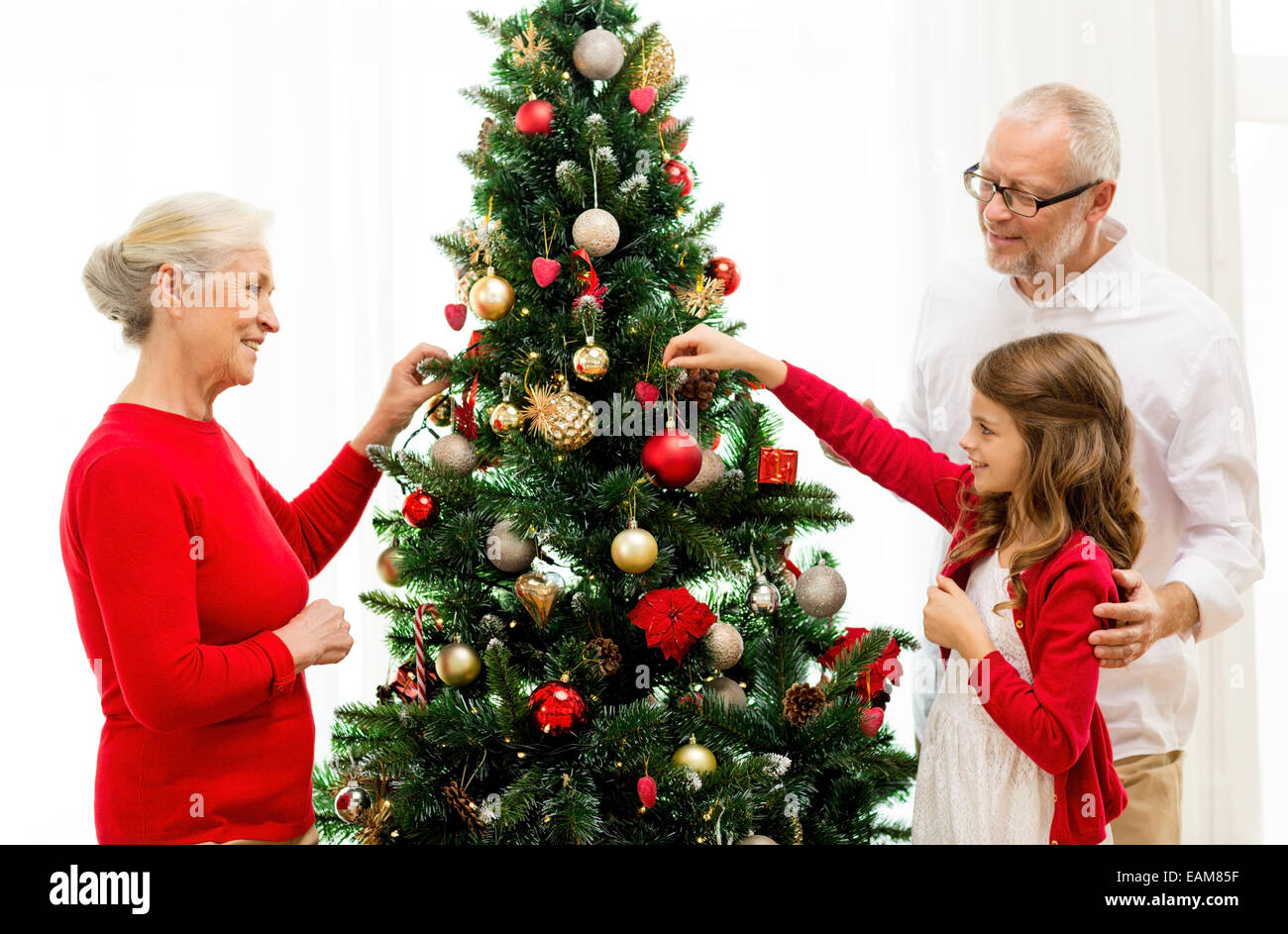 smiling family decorating christmas tree at home Stock Photo - Alamy