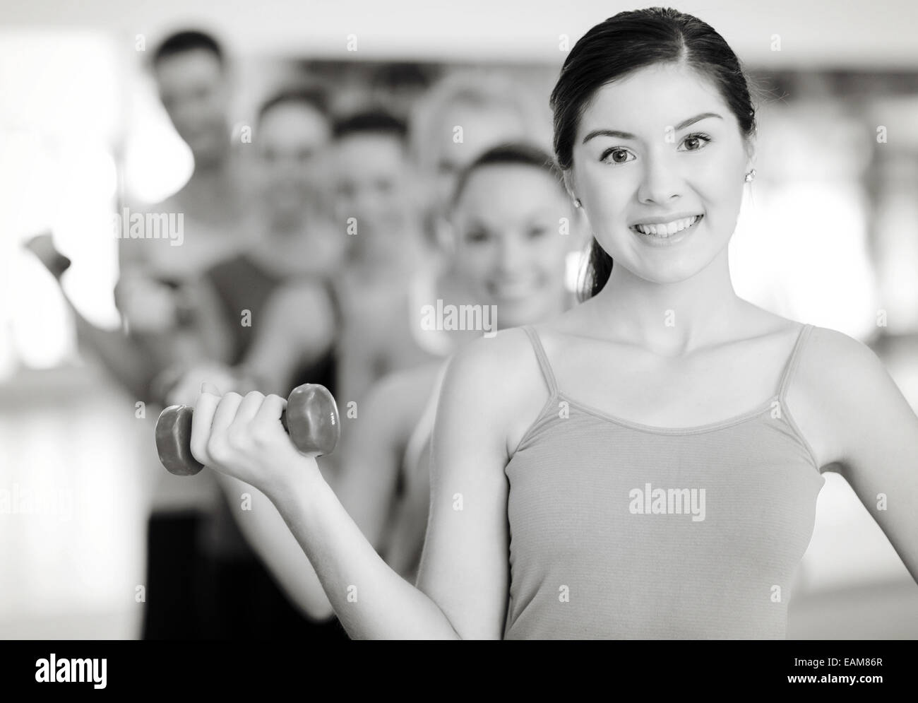 group of smiling people with dumbbells in the gym Stock Photo - Alamy