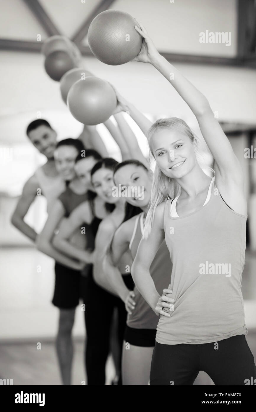 group of smiling people working out with ball Stock Photo - Alamy