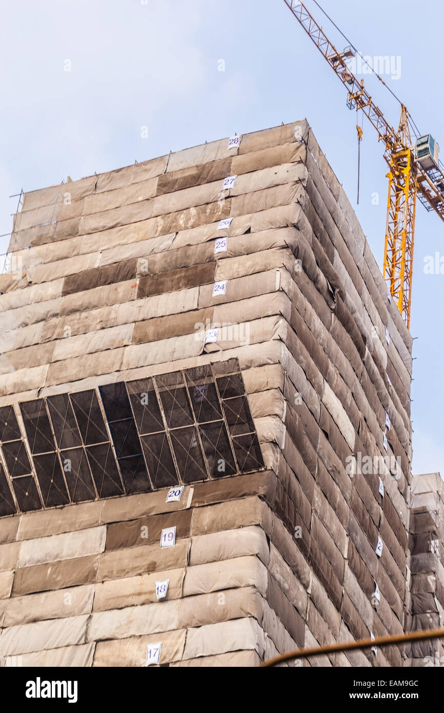 a skyscraper under construction or renovation with scaffolding Stock ...