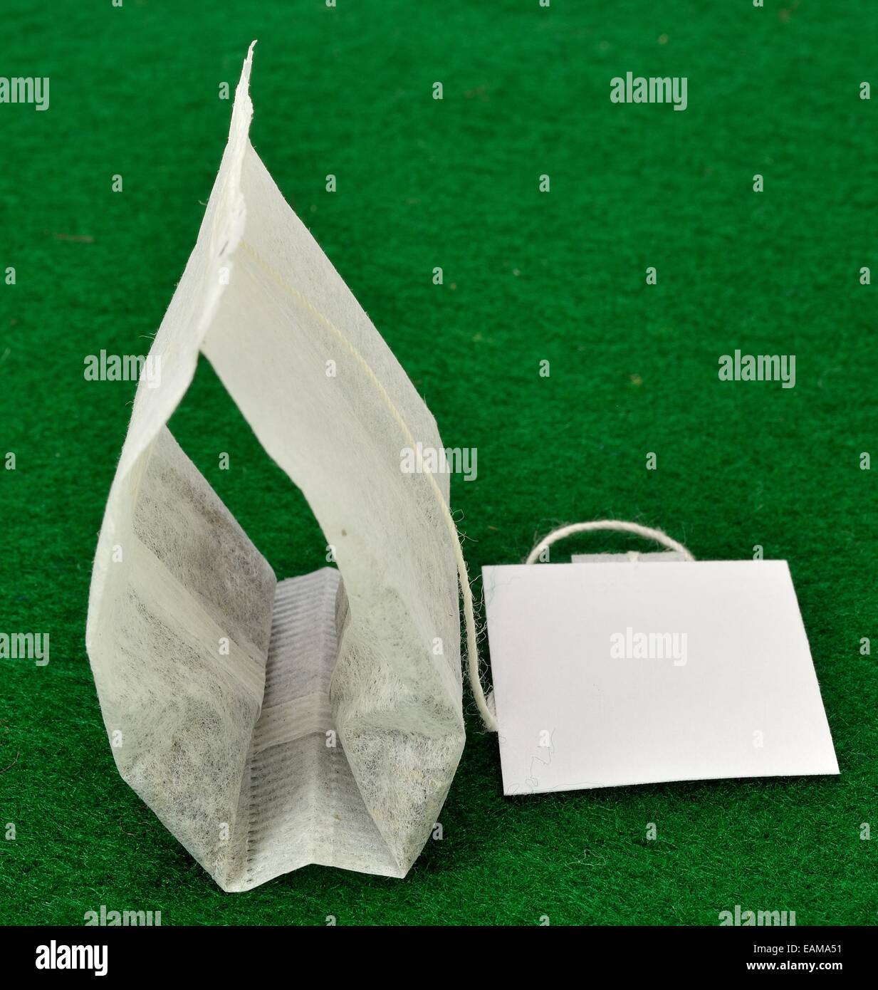 Single tea bag on a green background Stock Photo - Alamy