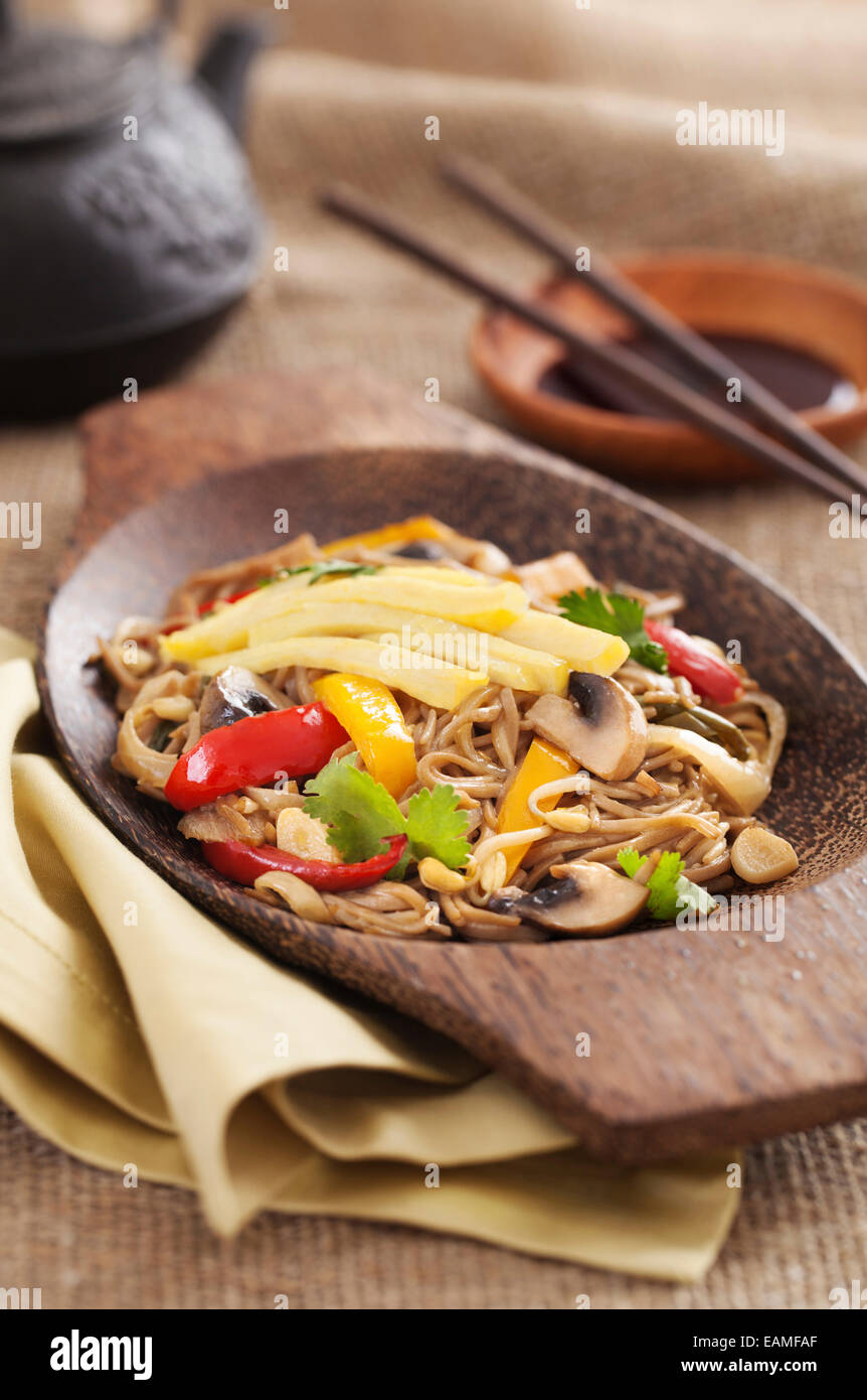Asian yakisoba noodle with fried vegetables and omelette on a wooden ...
