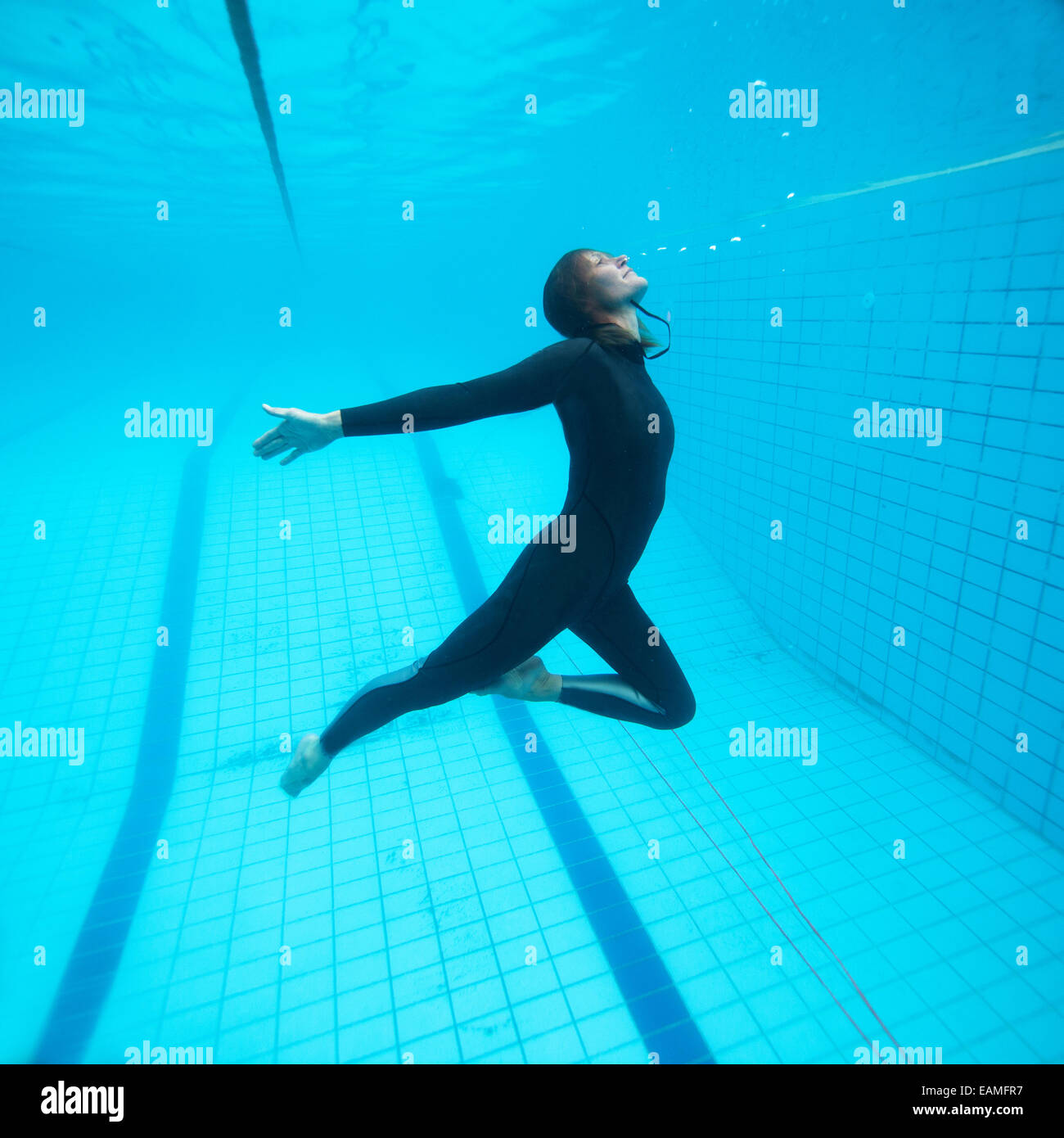 Female diver appearing to fly underwater in swimming pool Stock Photo ...