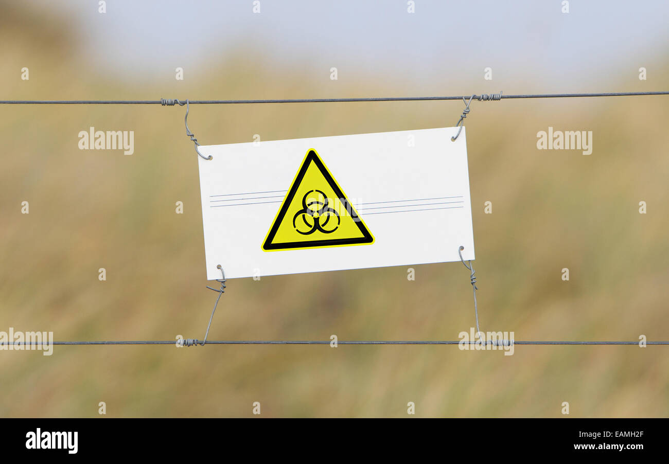 Border fence - Old plastic sign with a flag - Biohazard Stock Photo - Alamy