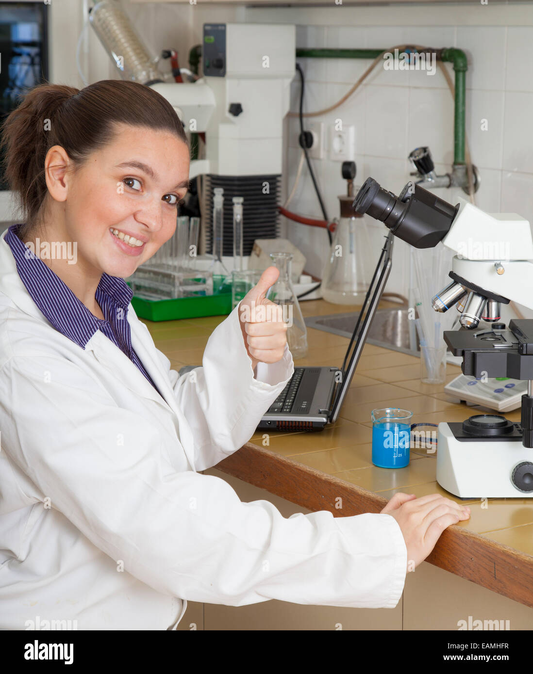 Cute smiling female researcher showing OK sign Stock Photo - Alamy