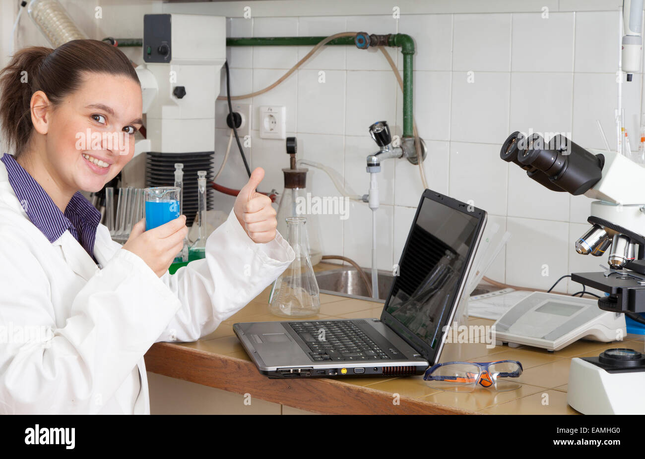 Cute smiling female researcher showing OK sign Stock Photo - Alamy